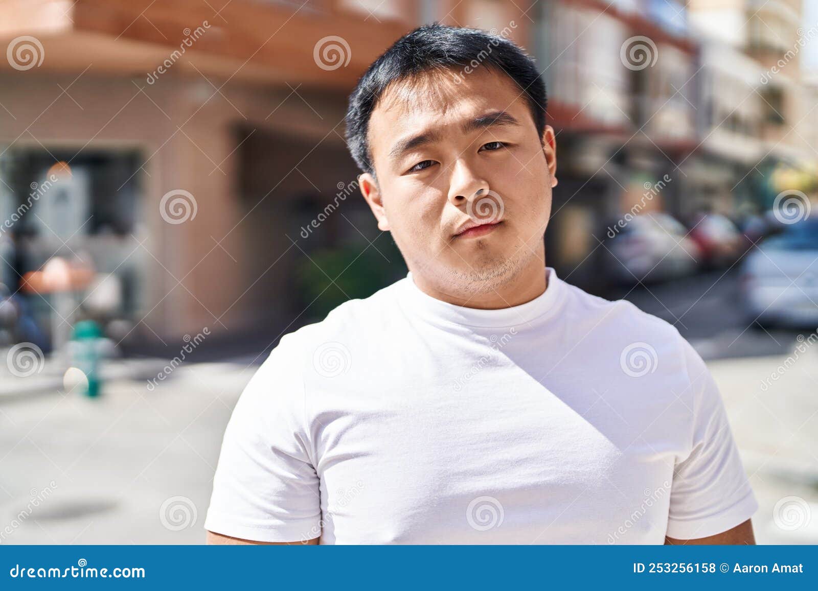 Young Chinese Man Standing with Relaxed Expression at Street Stock ...