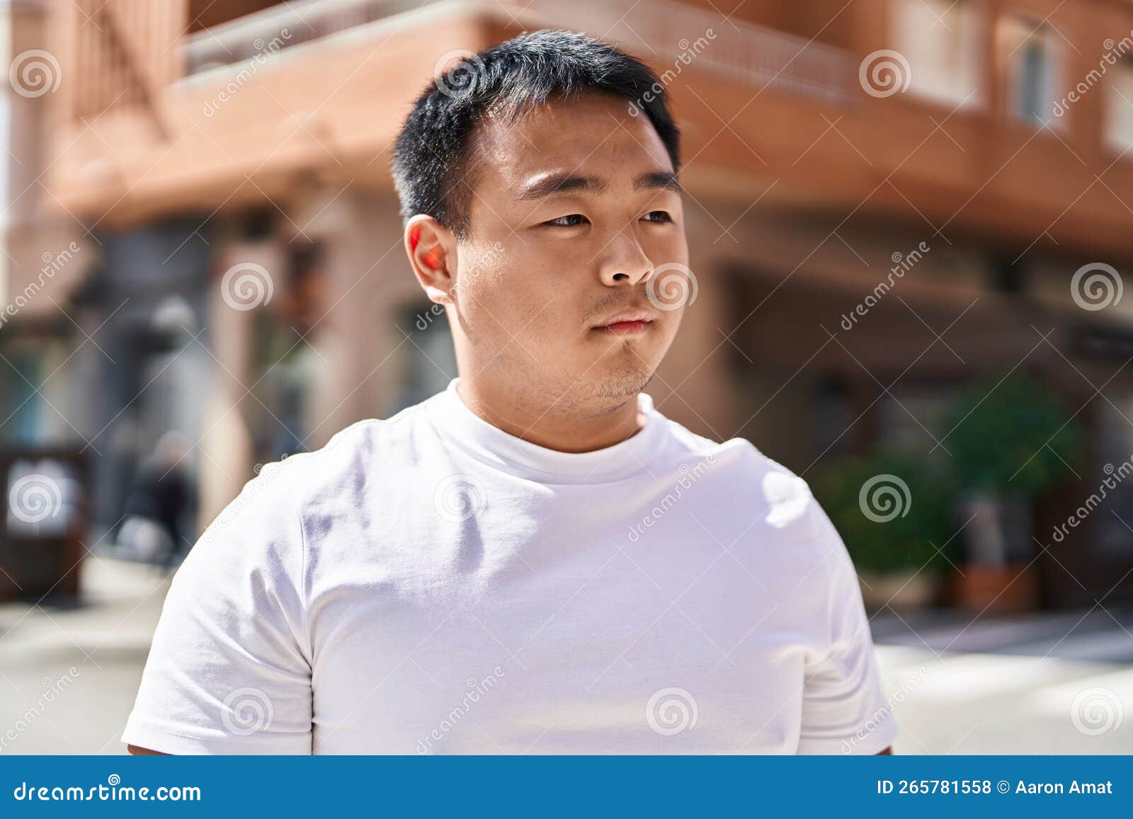 Young Chinese Man Standing with Relaxed Expression at Street Stock ...