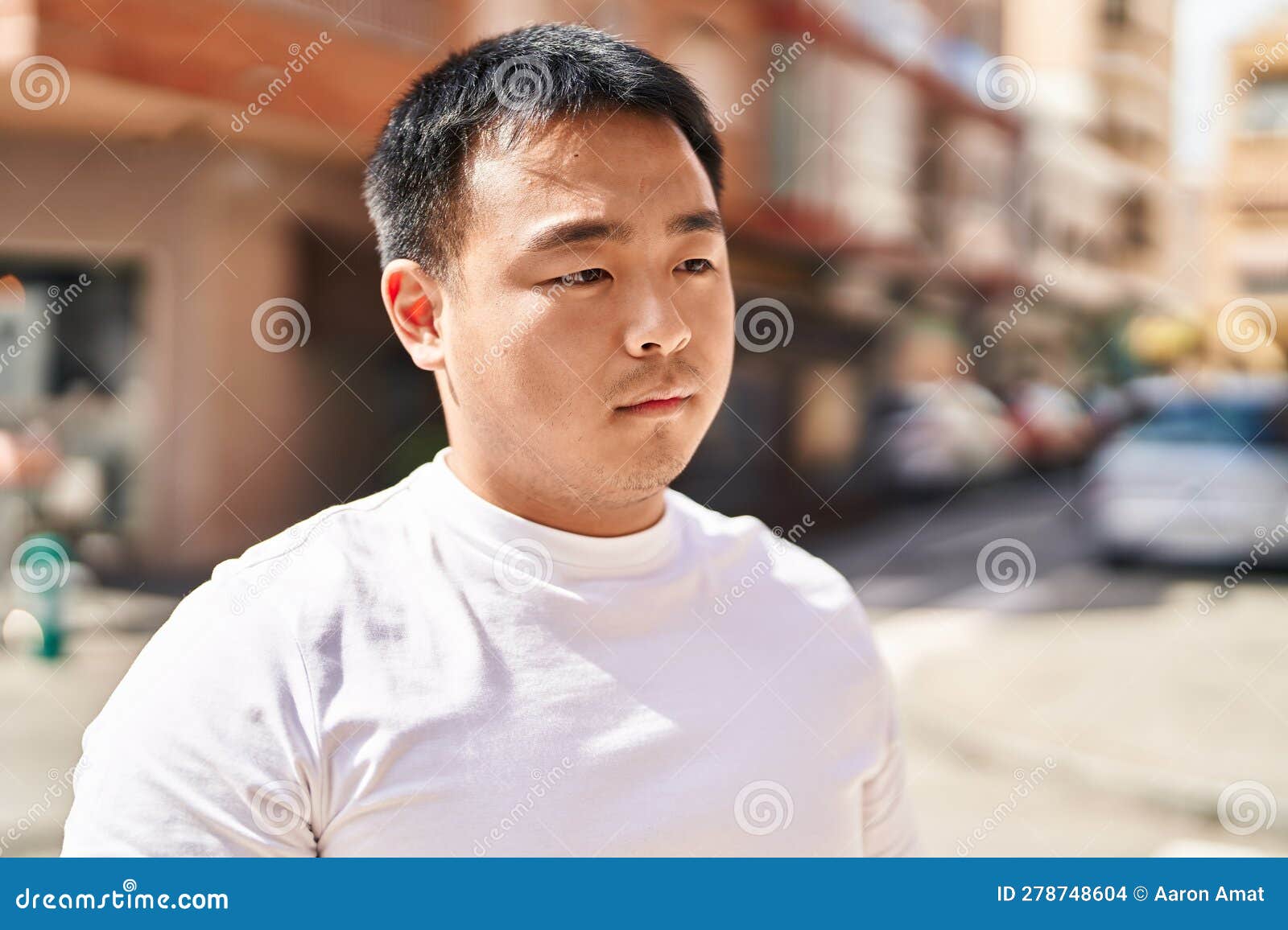 Young Chinese Man Standing with Relaxed Expression at Street Stock ...