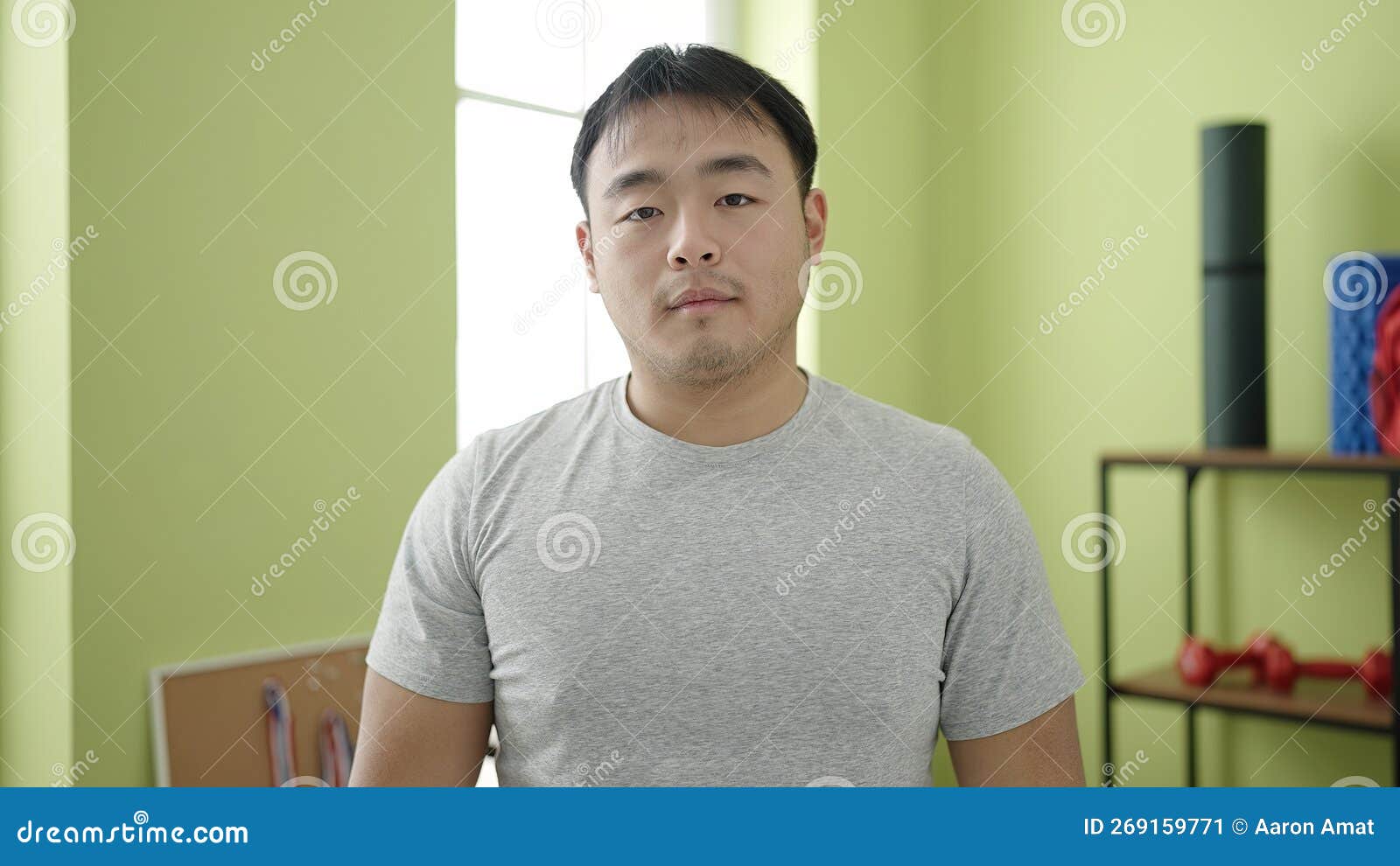 Young Chinese Man Standing with Serious Expression at Sport Center ...