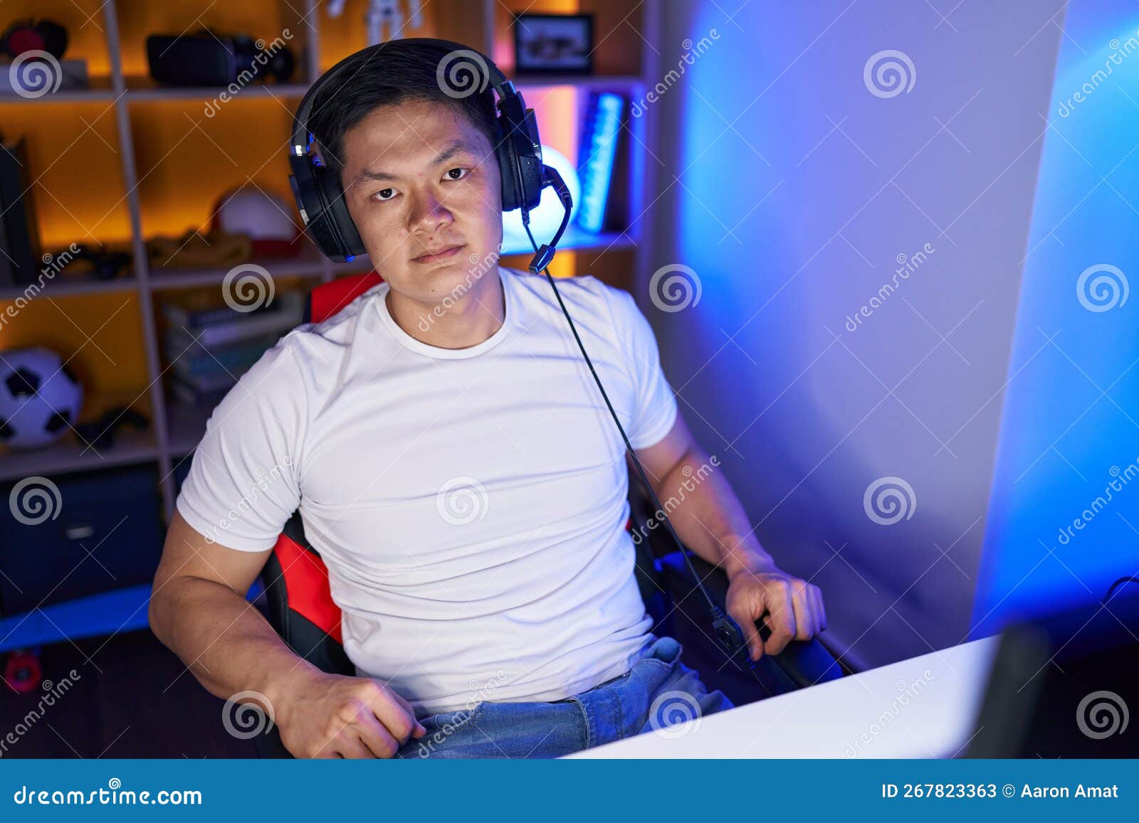 Young Chinese Man Streamer Sitting on Table with Serious Expression at ...