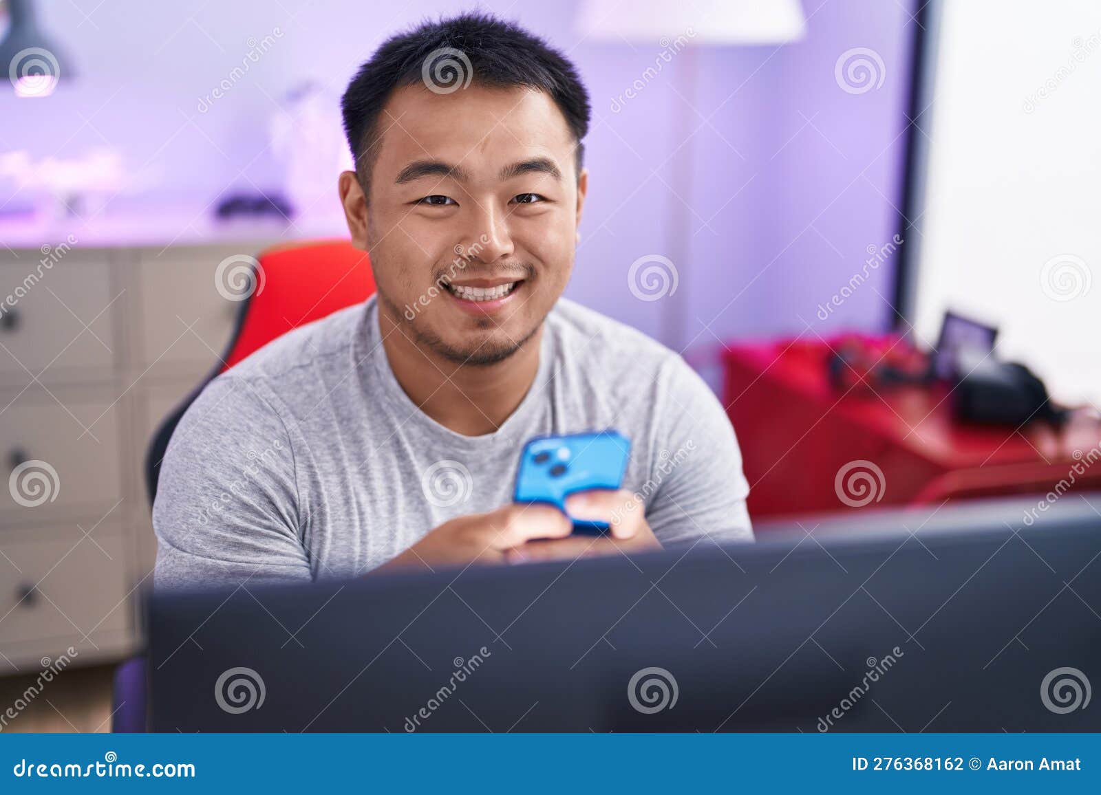 Young Chinese Man Streamer Using Computer and Smartphone at Gaming Room ...