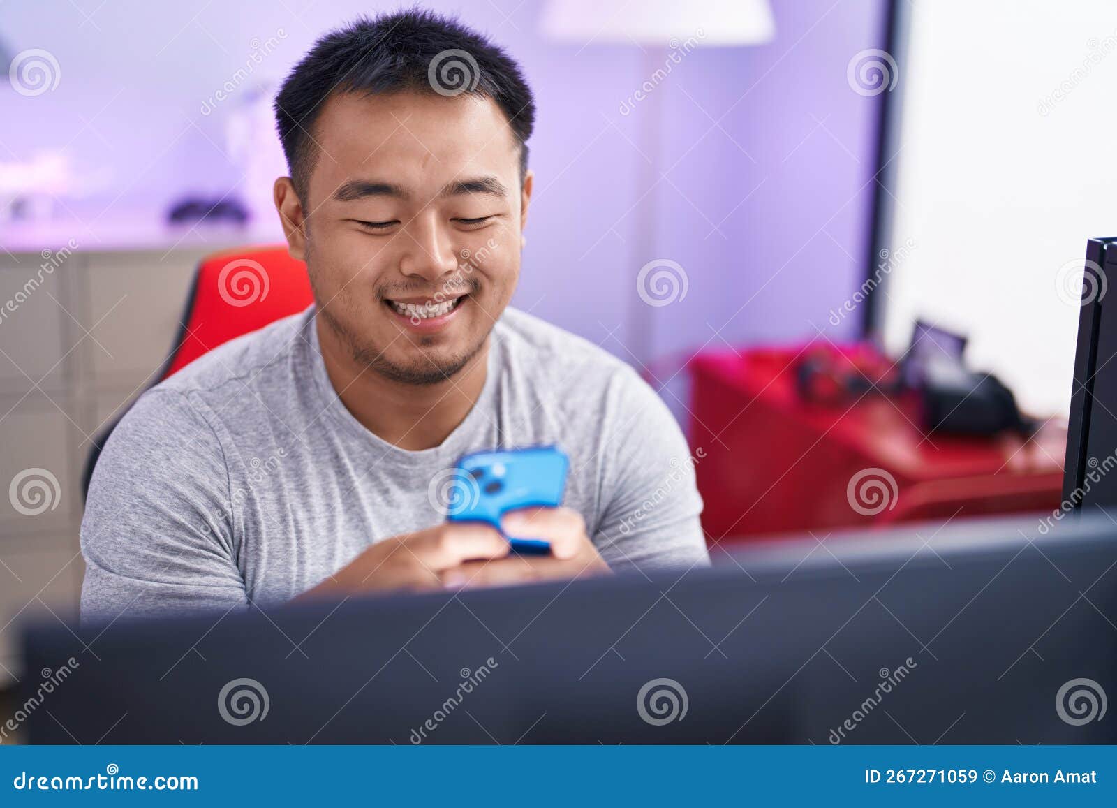Young Chinese Man Streamer Using Computer and Smartphone at Gaming Room ...