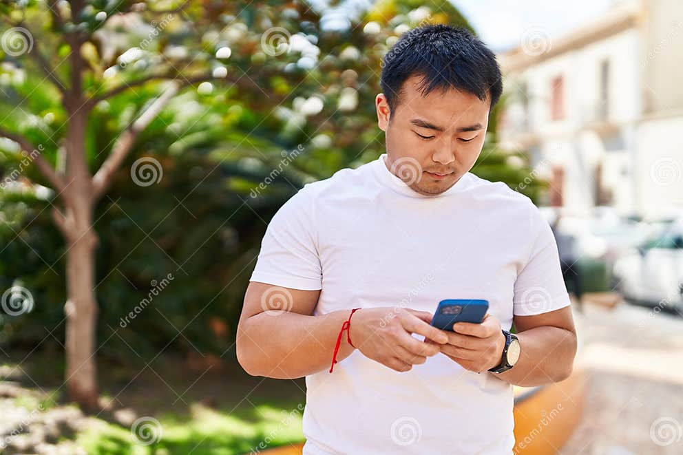 Young Chinese Man Using Smartphone at Park Stock Image - Image of ...