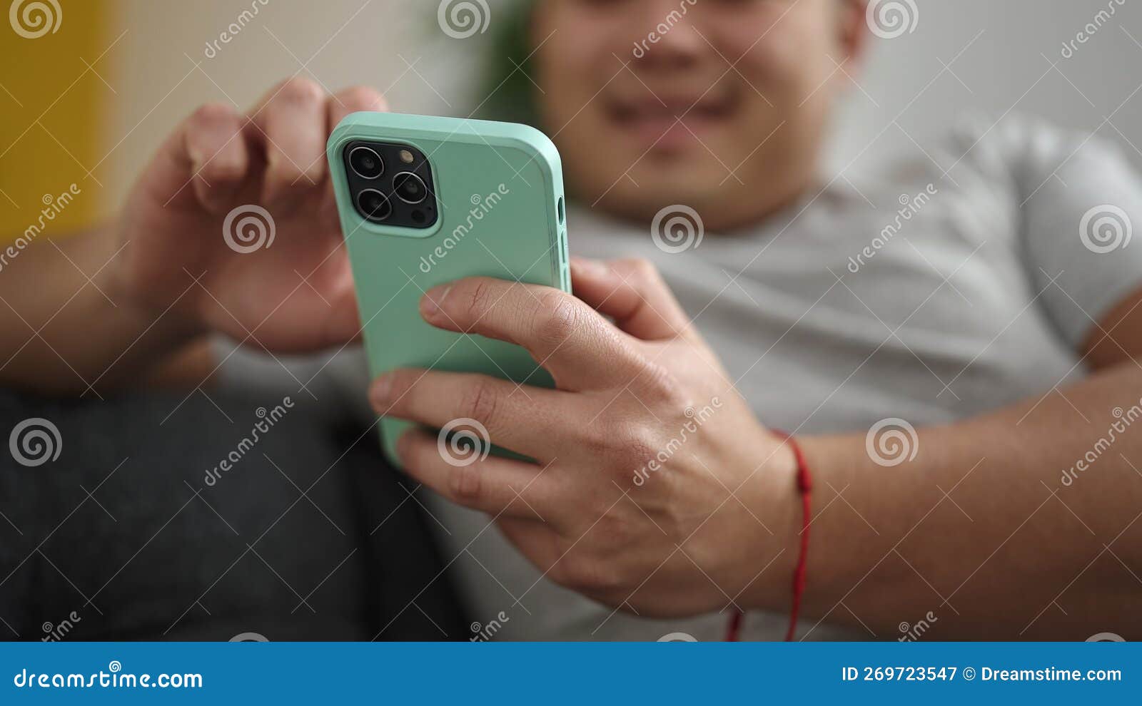 Young Chinese Man Using Smartphone Sitting on Sofa at Home Stock Image ...