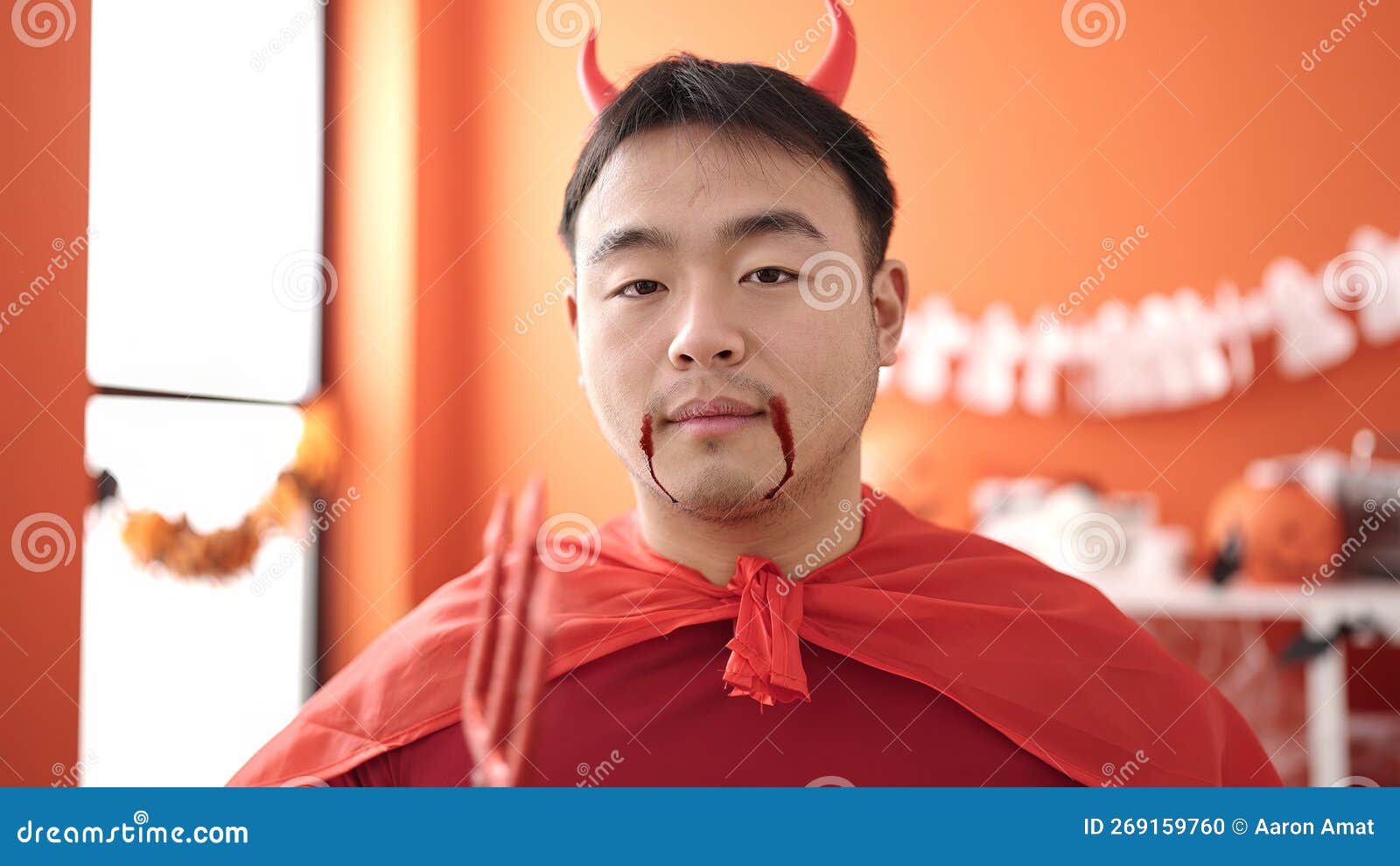 Young Chinese Man Wearing Devil Costume Holding Trident at Home Stock ...