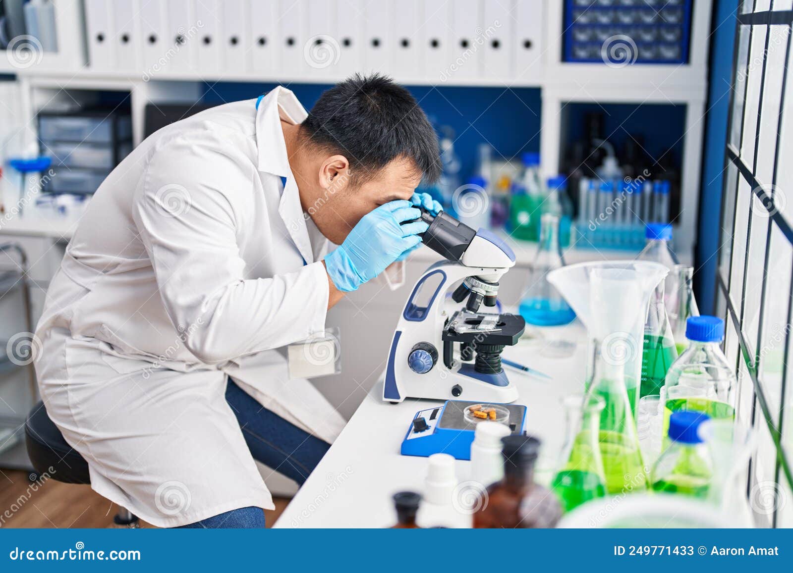 Young Chinese Man Wearing Scientist Uniform Using Microscope at ... Young Chinese Man Wearing Scientist Uniform Using Microscope at ...