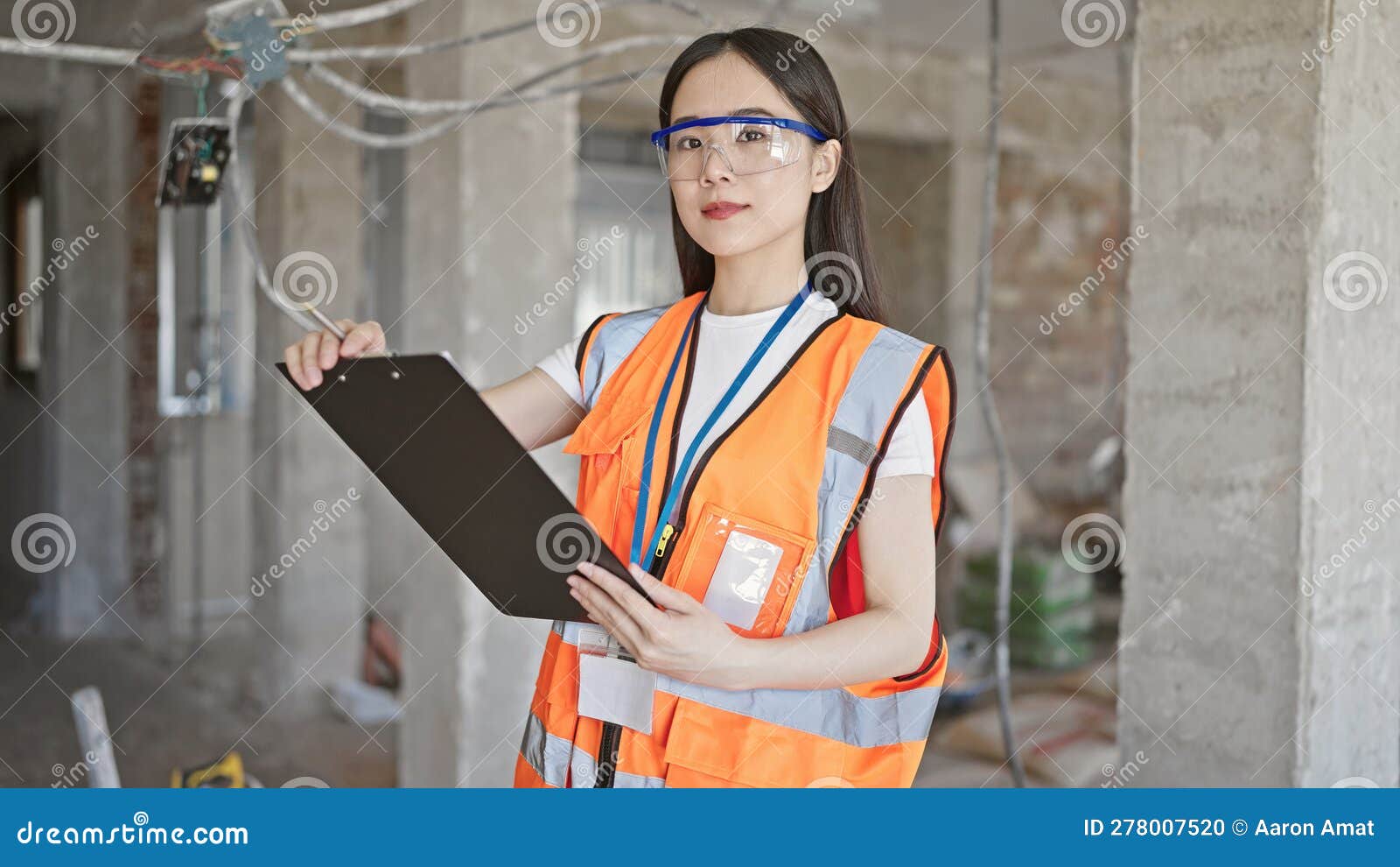 Young Chinese Woman Builder Smiling Confident Reading Document at ...