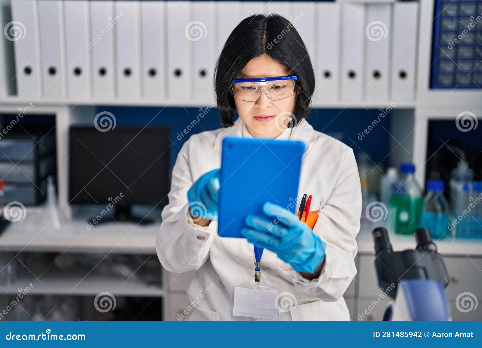 Young Chinese Woman Scientist Using Touchpad Working at Laboratory ...