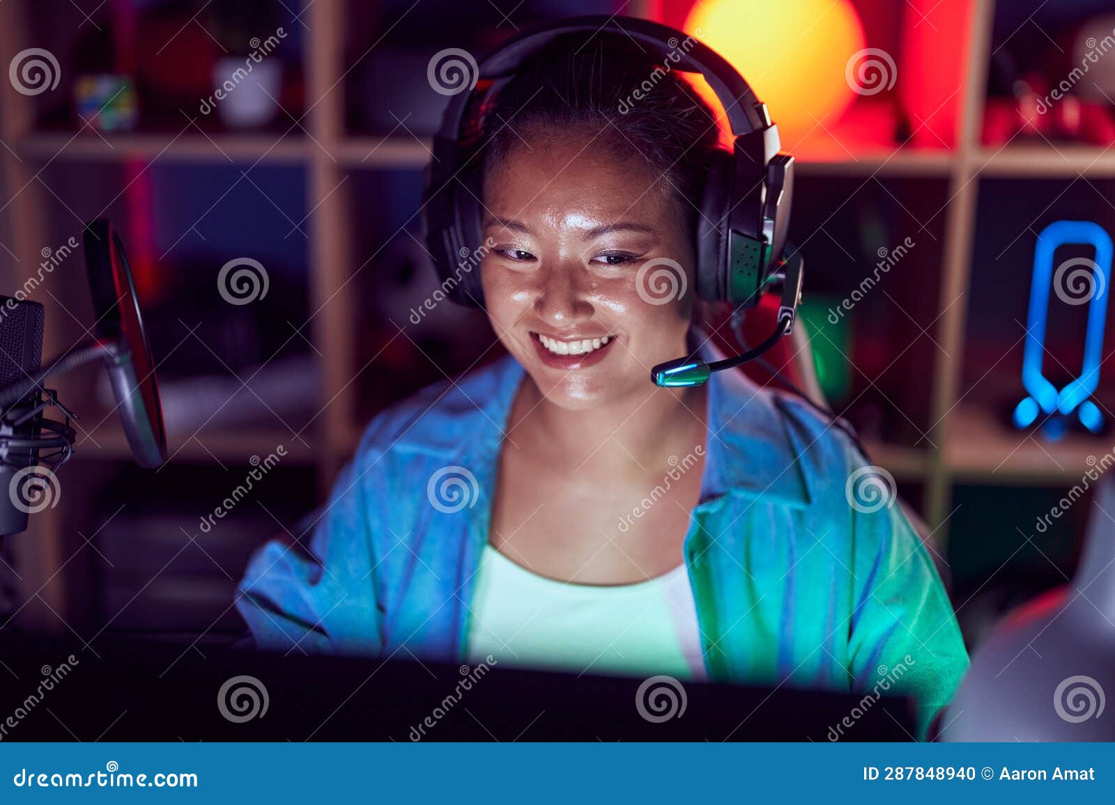 Young Chinese Woman Streamer Playing Video Game Using Computer at ...