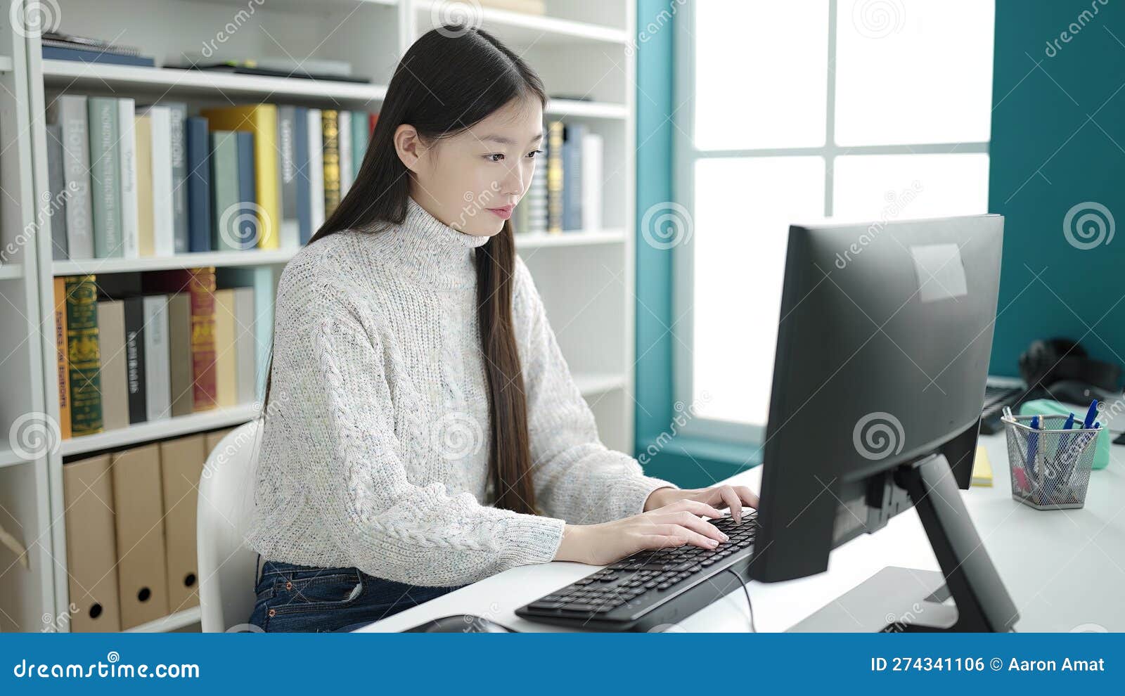 Young Chinese Woman Student Using Computer Studying at Library ...