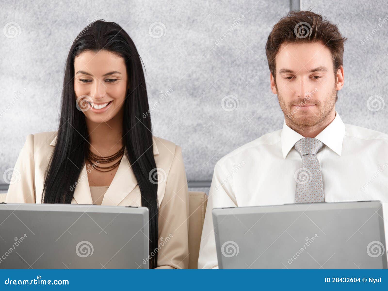 Young Colleagues Working on Laptop Smiling Stock Photo - Image of ...