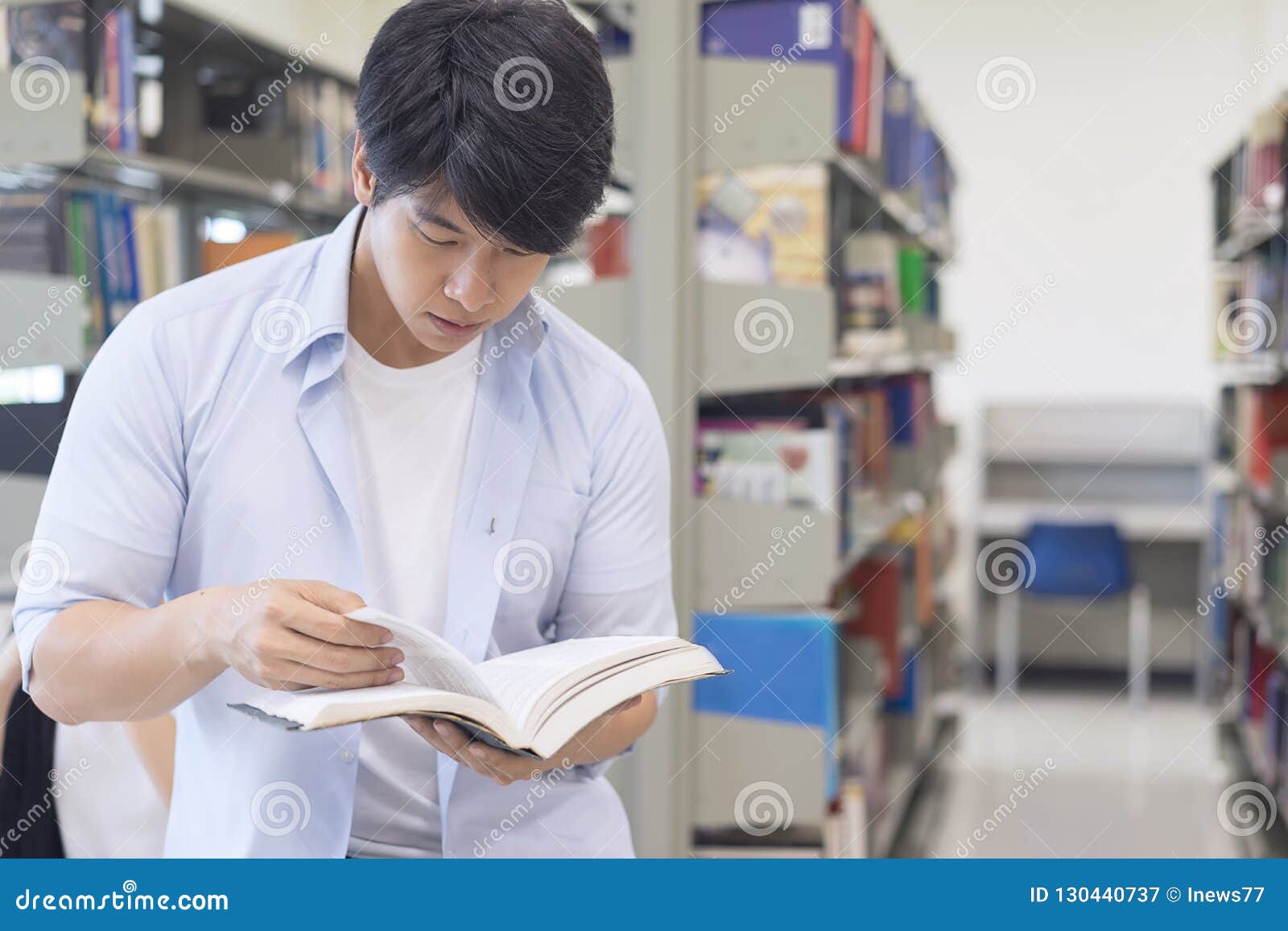 Young College Student Reading a Book in Library. Education and S Stock ...