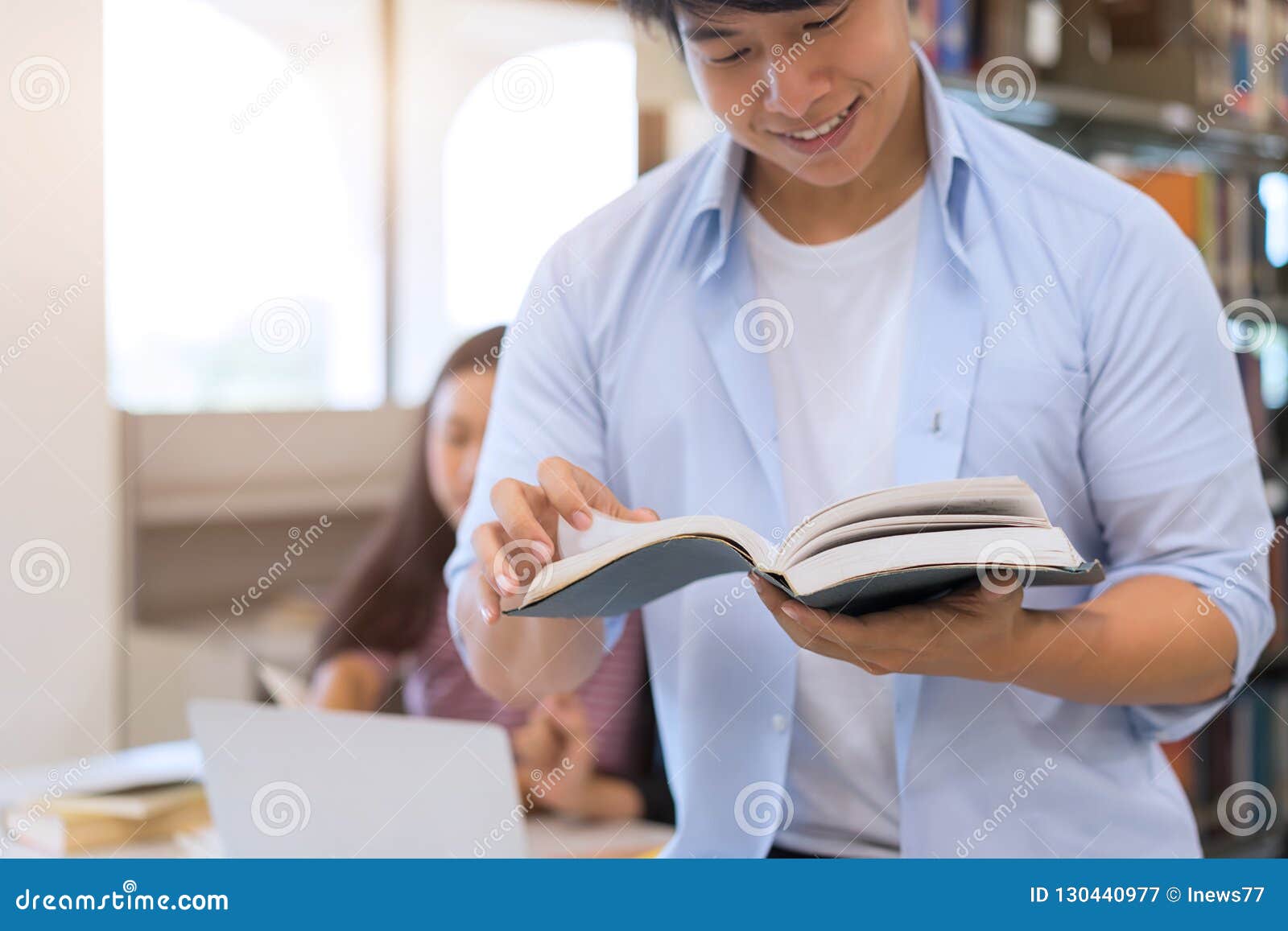 Young College Student Reading a Book in Library. Education and S Stock ...