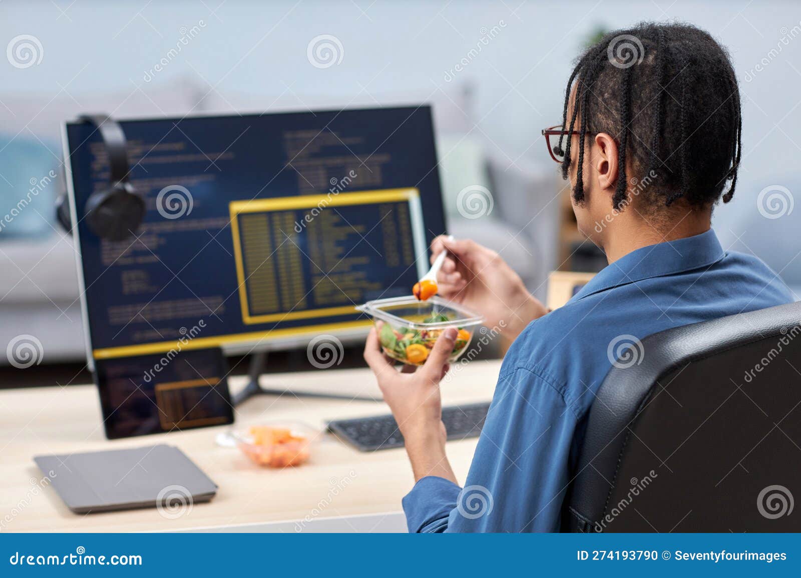 Young Computer Programmer Eating Takeout Lunch at Workplace while ...