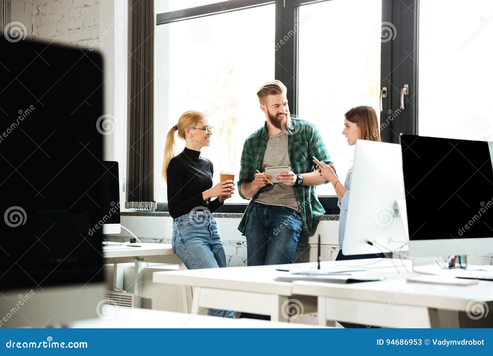 Young Concentrated Colleagues in Office Talking with Each Other Stock ...