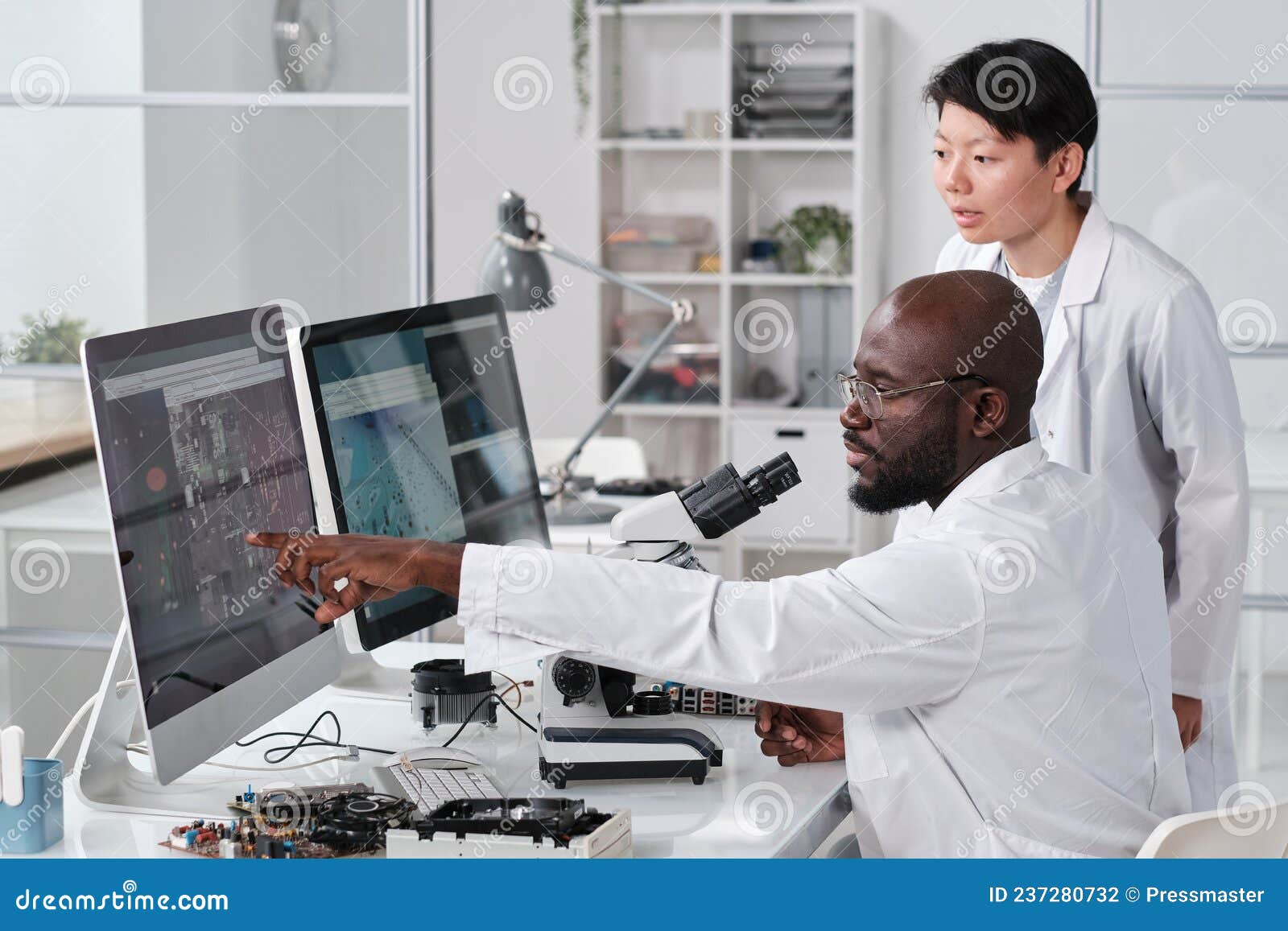 Young Confident Scientist Pointing at Magnified Microchip Scheme on ...