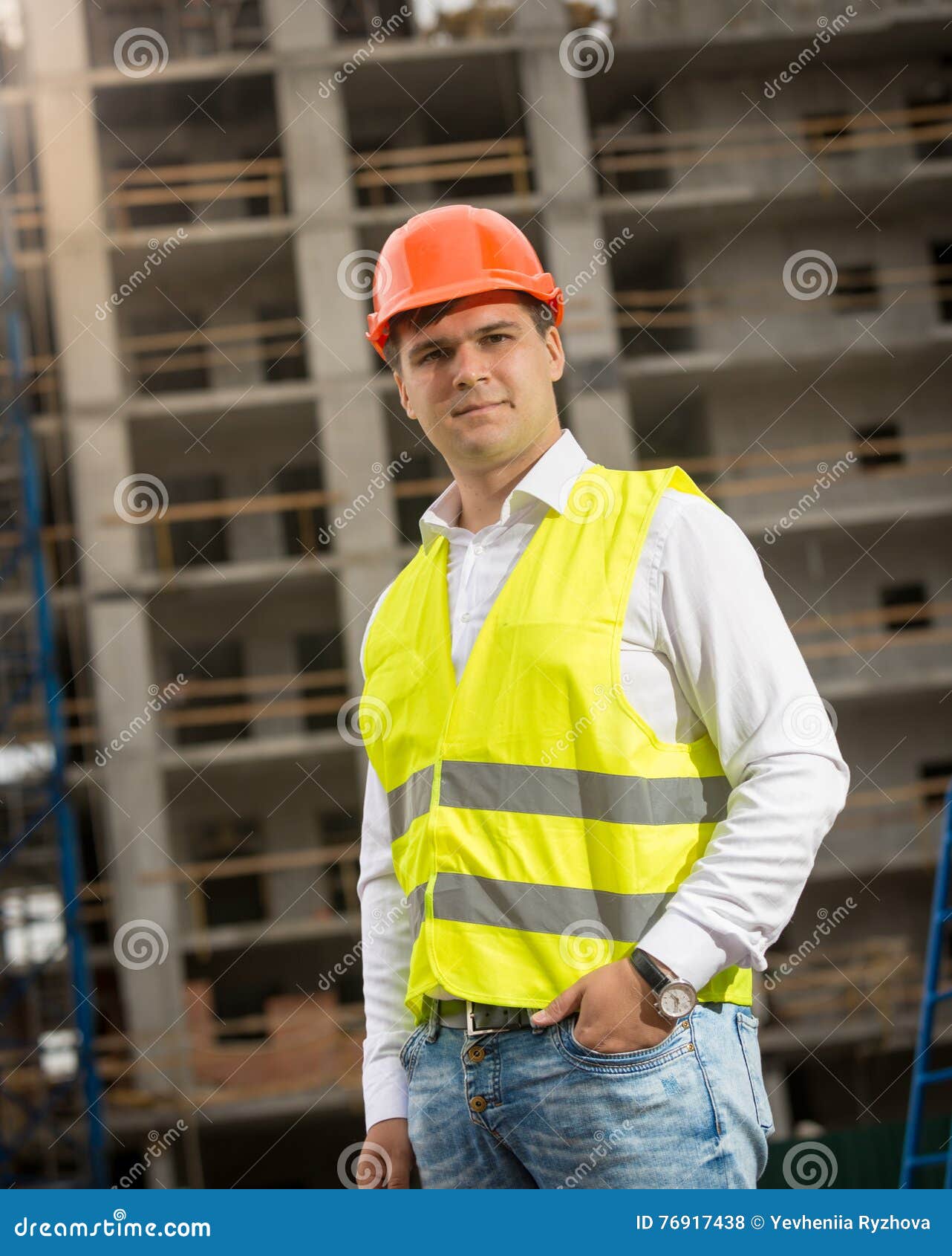 Young Construction Engineer Standing at Building Site and Looking at ...
