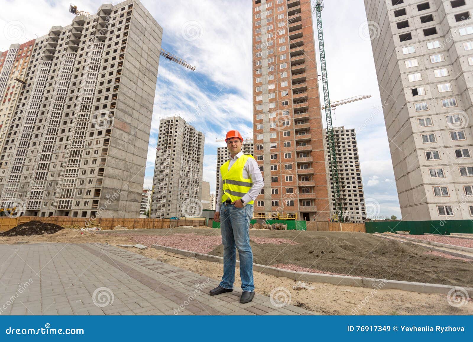 Young Construction Engineer Standing in Front of Buildings Under Stock ...