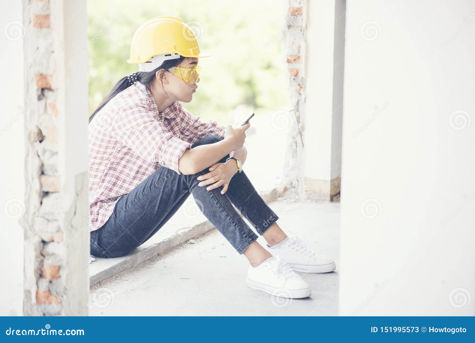 Young Construction Worker Holding Smart Phone and Sittin at ...