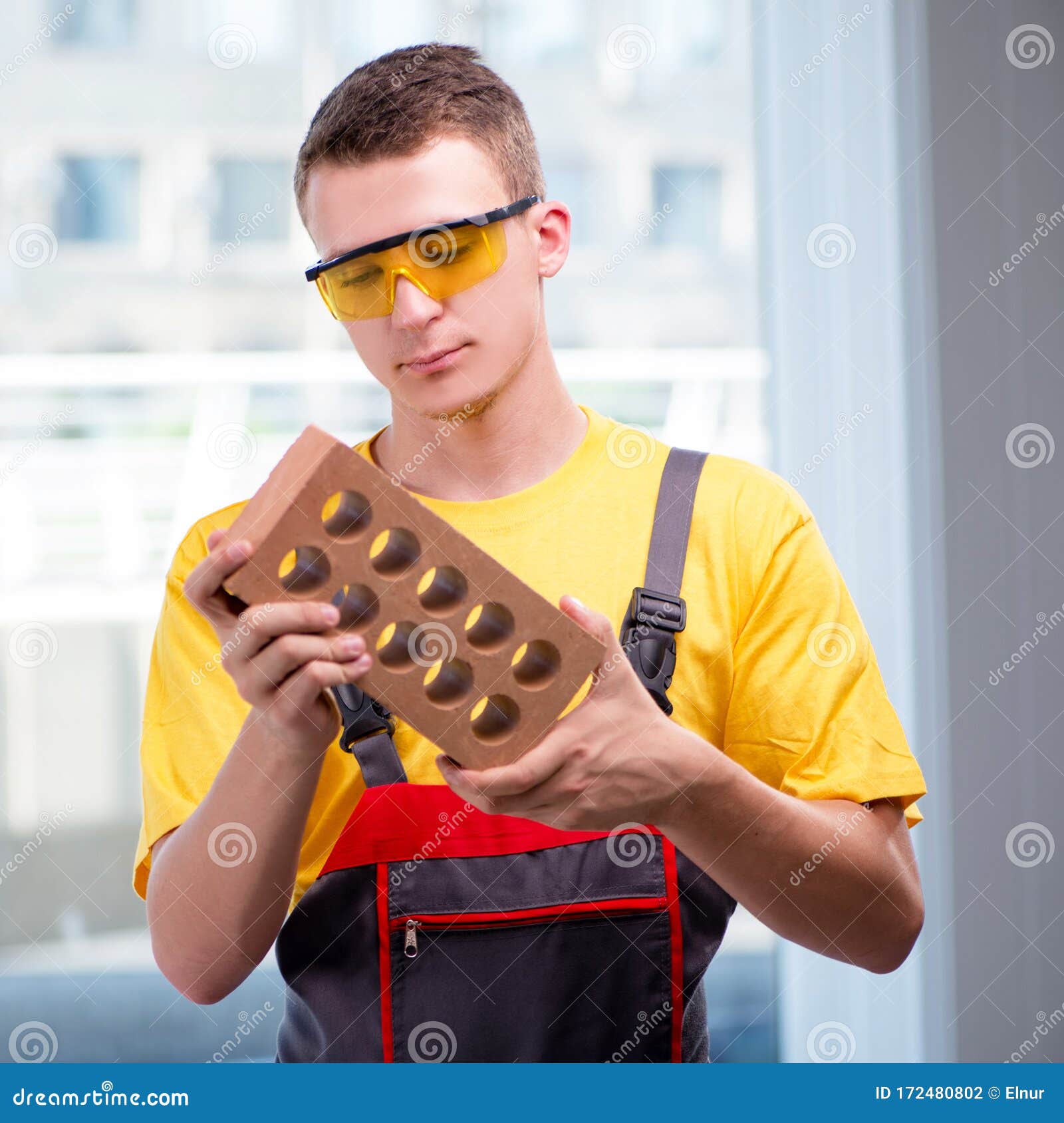 Young Construction Worker in Yellow Coveralls Stock Photo - Image of ...