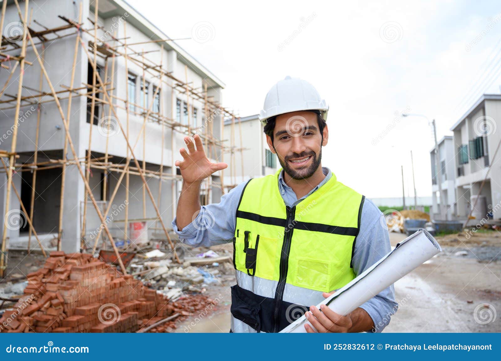 Young Constructor Engineer Man Smiling Holding Blueprint while Talking about Building ...