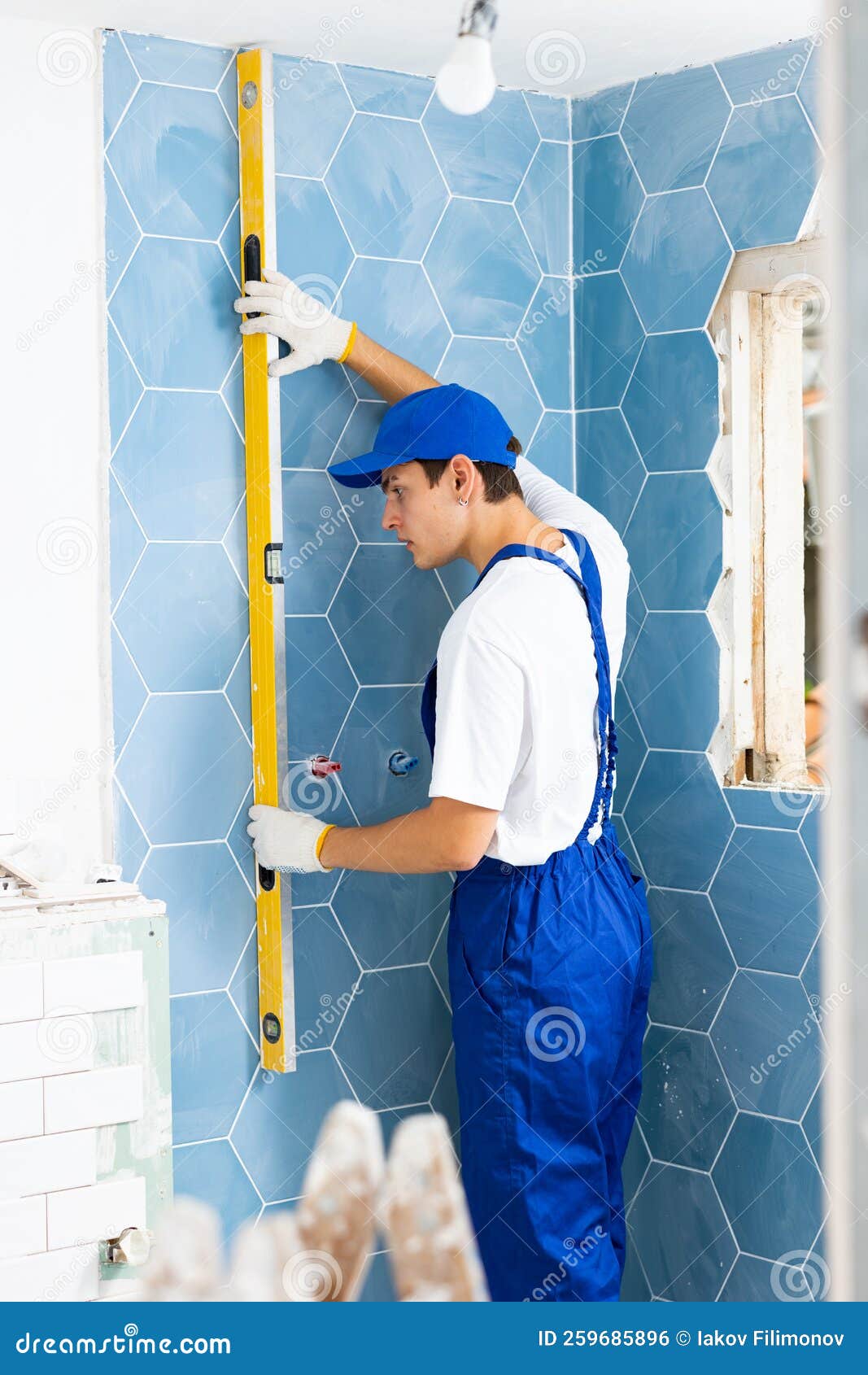 Contractor Inspecting Quality of Ceramic Tiles Laid with Level Meter ...