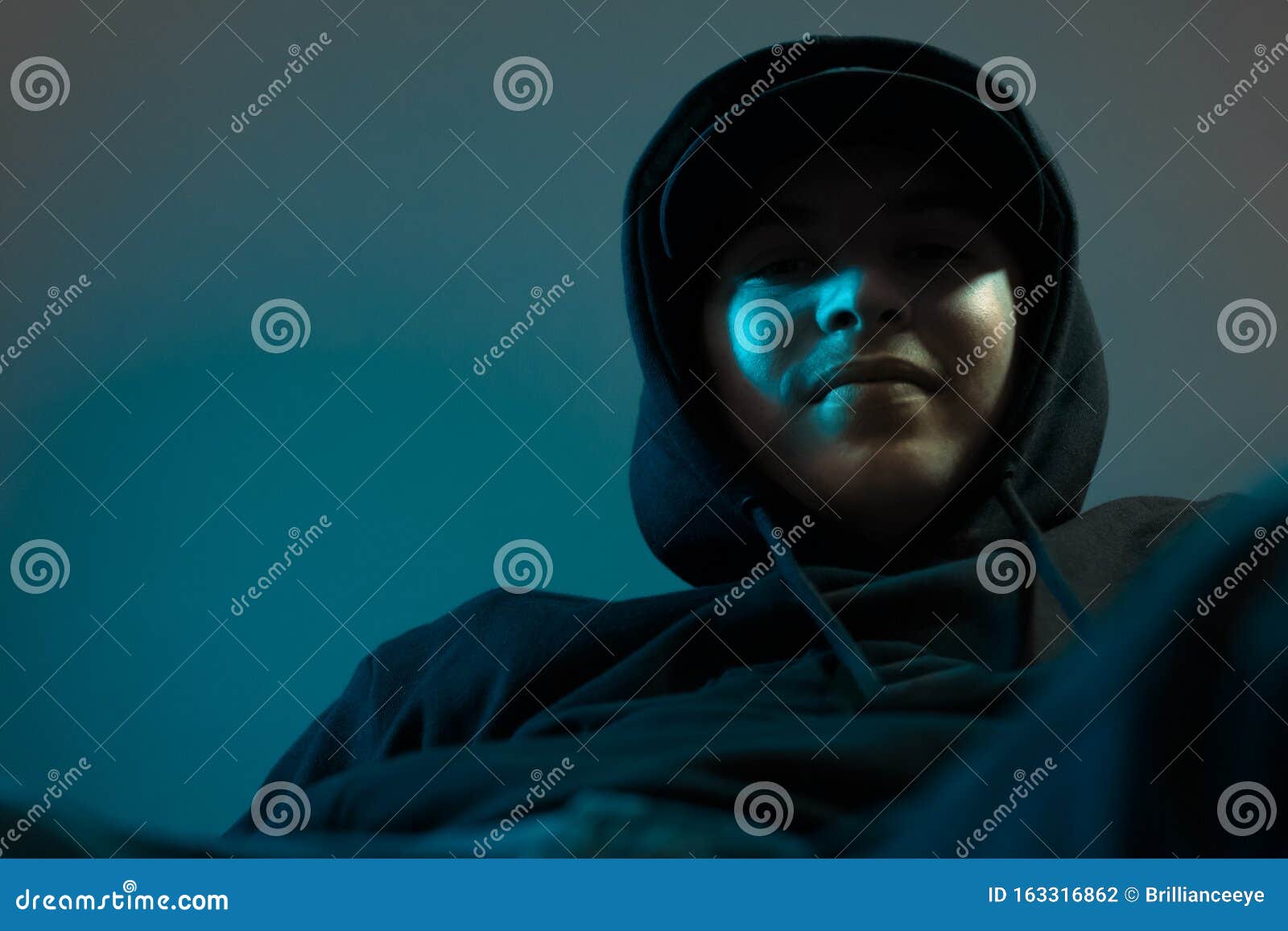 Young Cool Smiling Rapper with Black Hoodie and Cap Looking Down Stock ...