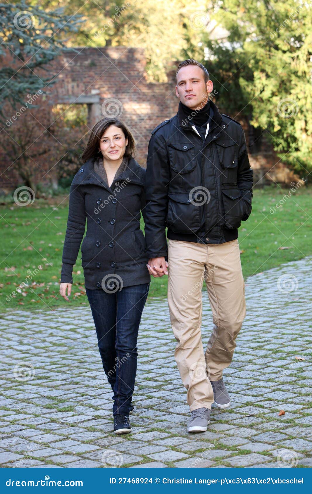 Young Couple Approaching Walking Hand in Hand Stock Photo - Image of ...
