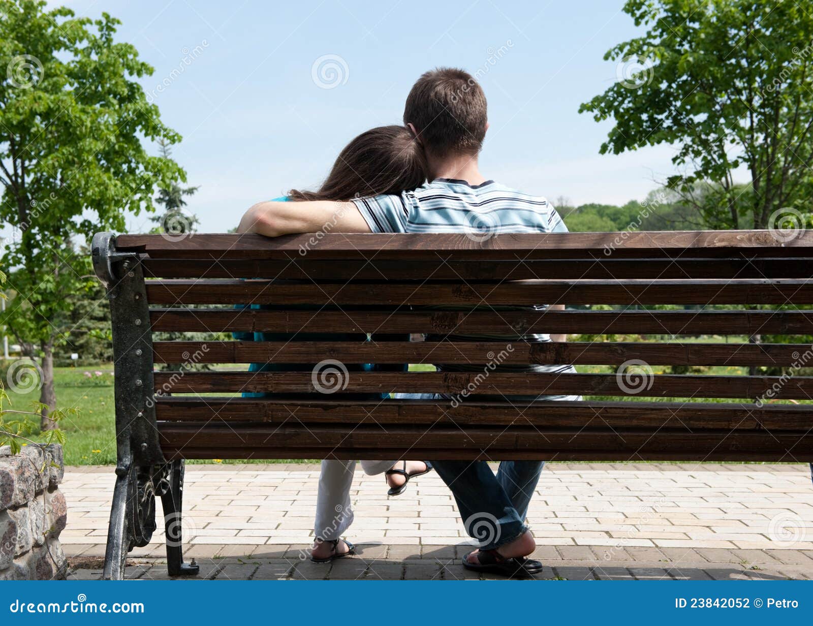 Young couple on bench stock photo. Image of embracing - 23842052