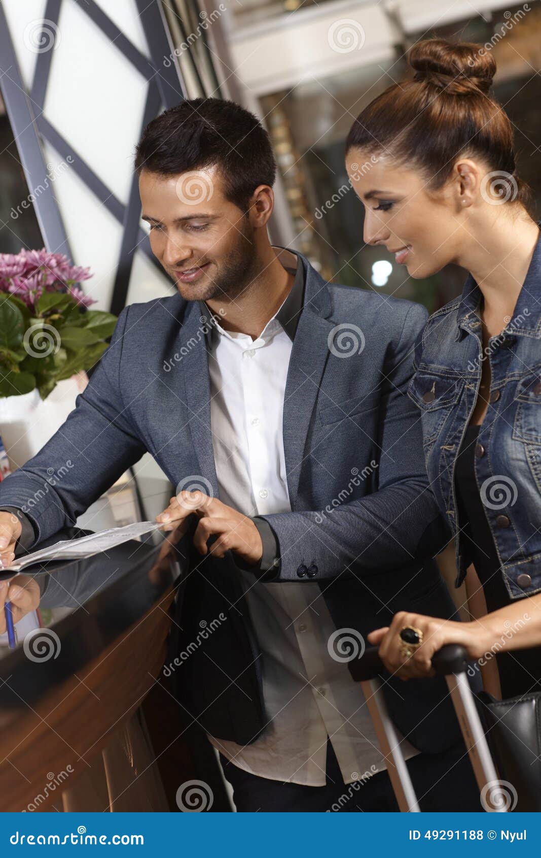 Young Couple Checking in at Hotel Reception Stock Photo - Image of ...