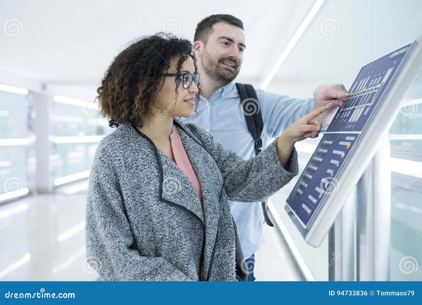 Young Couple Checking the Timetable Stock Photo - Image of airport ...