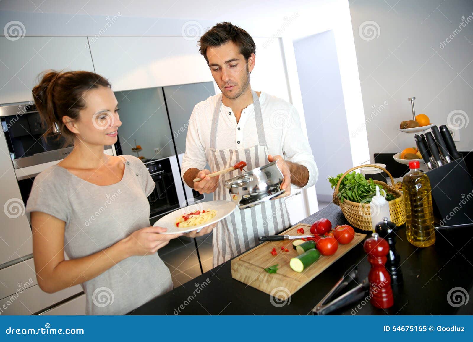 Young couple cooking pasta stock image. Image of meal - 64675165