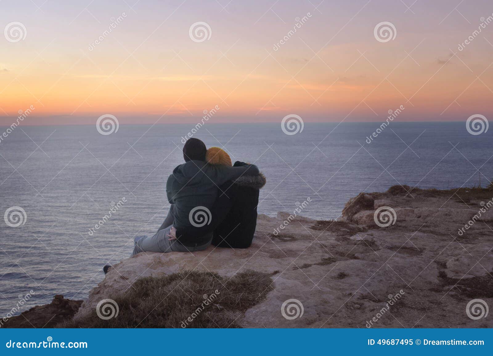 Young Couple Cuddling on a Cliff at Sunset Stock Image - Image of ...