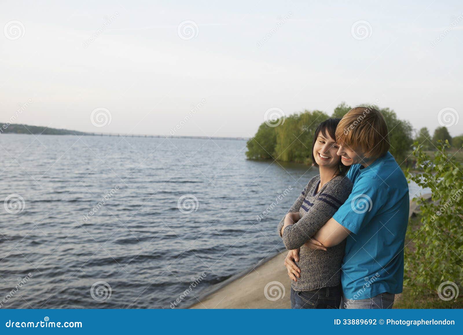 Young Couple Cuddling on Lakeshore Stock Photo - Image of caucasian ...