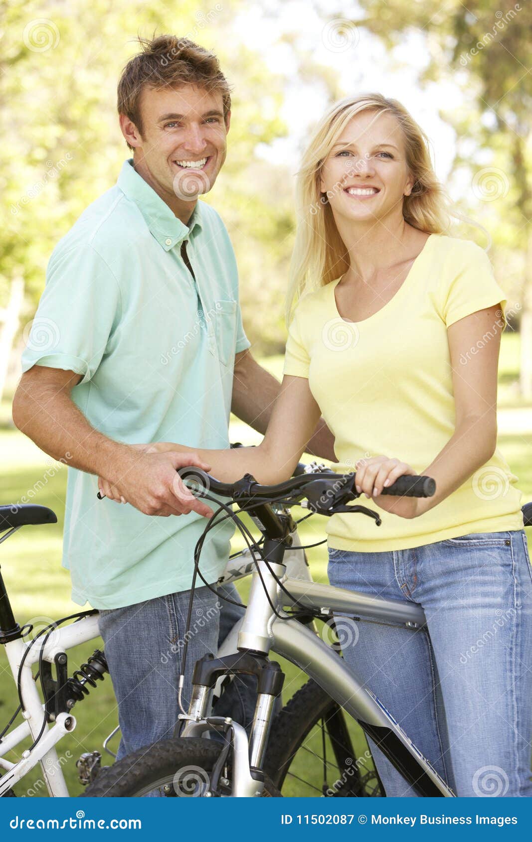 Young Couple on Cycle Ride in Park Stock Image - Image of couple, smile ...