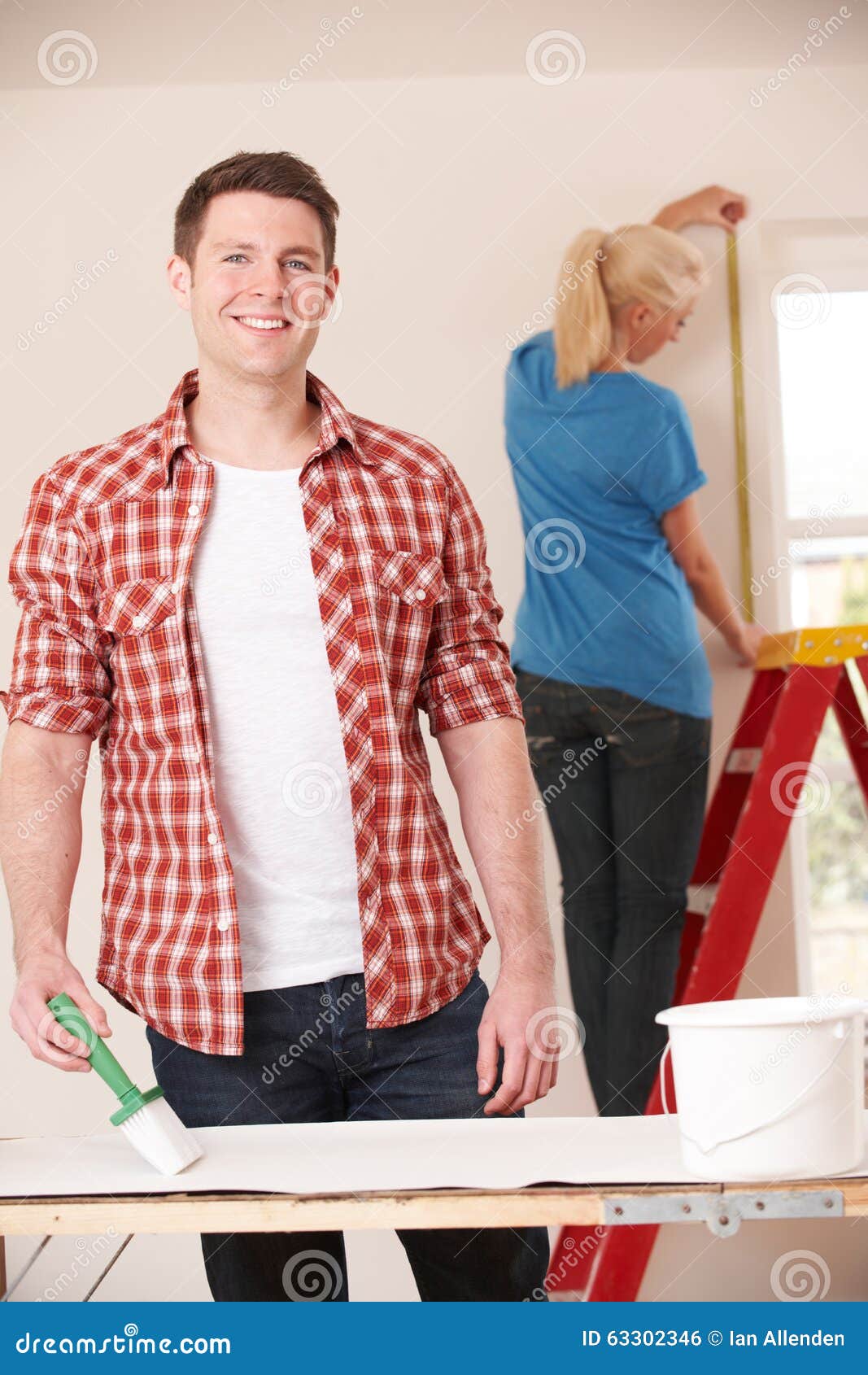 Young Couple Decorating New Home Together Stock Photo - Image of ...