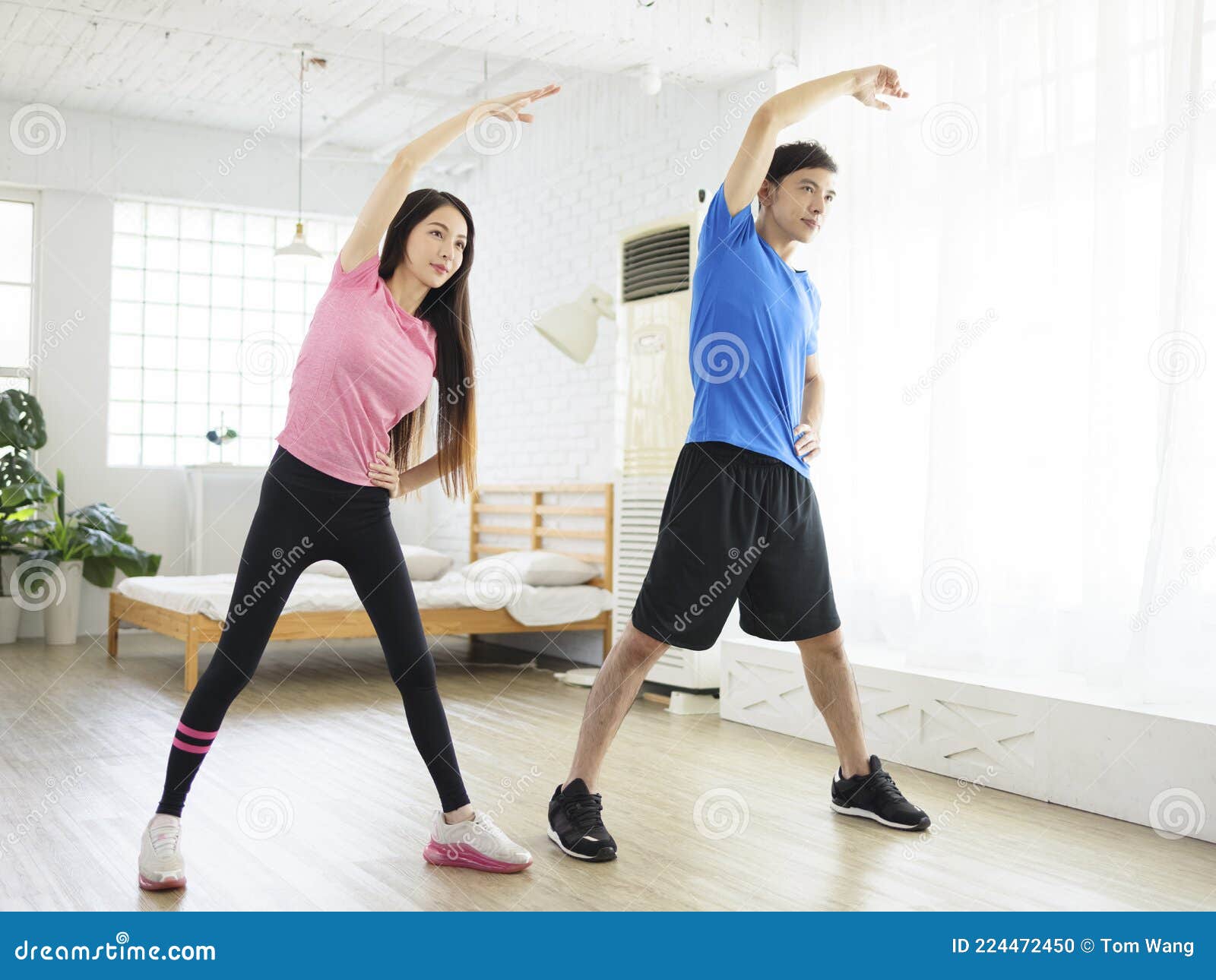 Young Couple Doing Lateral Flexion Exercise at Home Stock Photo - Image ...