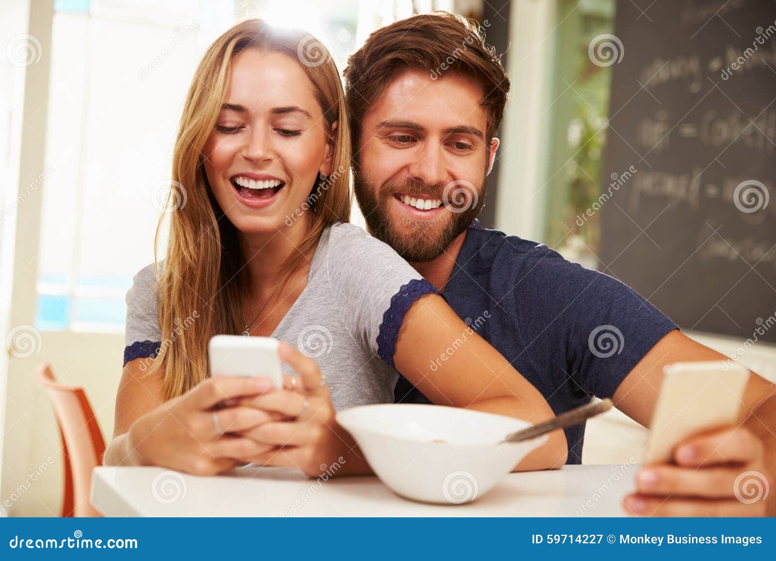 Young Couple Eating Breakfast Whilst Using Mobile Phones Stock Image ...