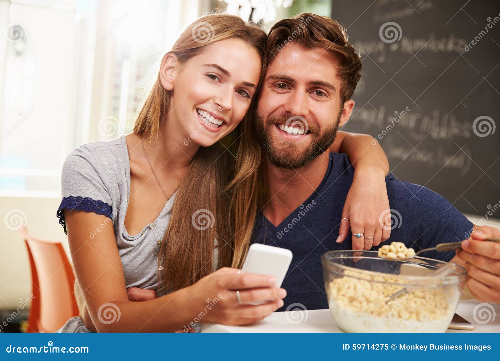 Young Couple Eating Breakfast Whilst Using Mobile Phones Stock Image ...