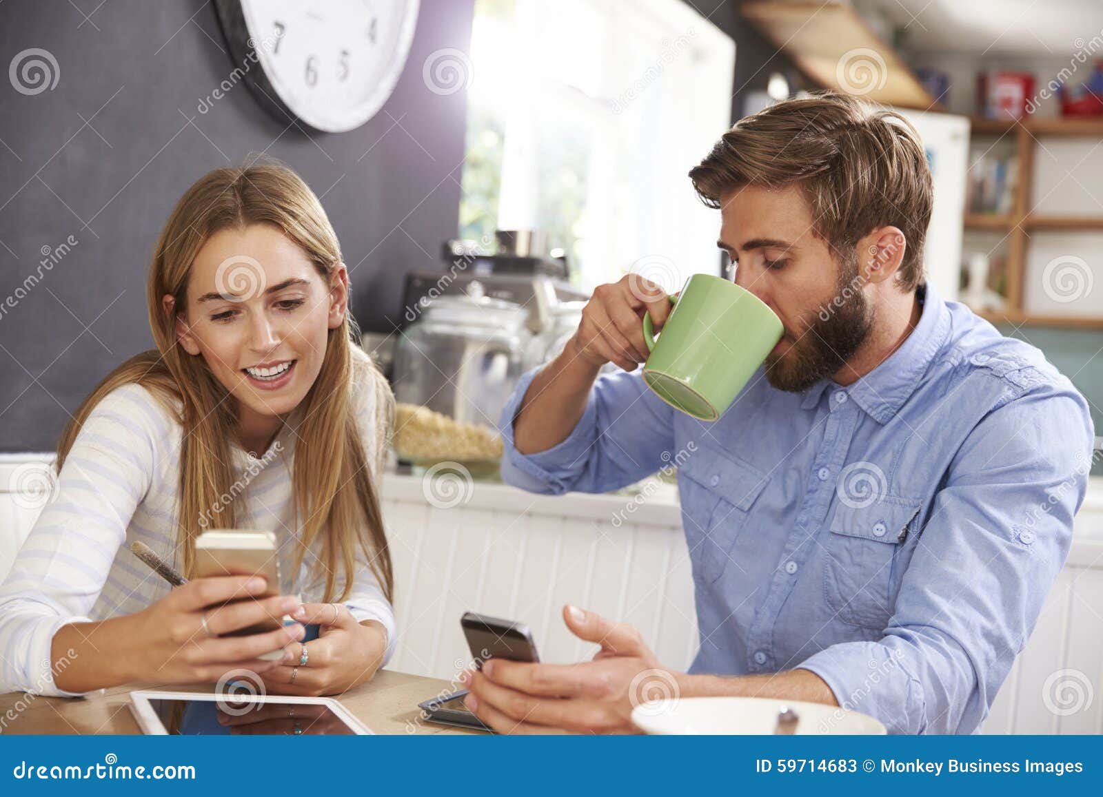 Young Couple Eating Breakfast Whilst Using Mobile Phones Stock Image ...