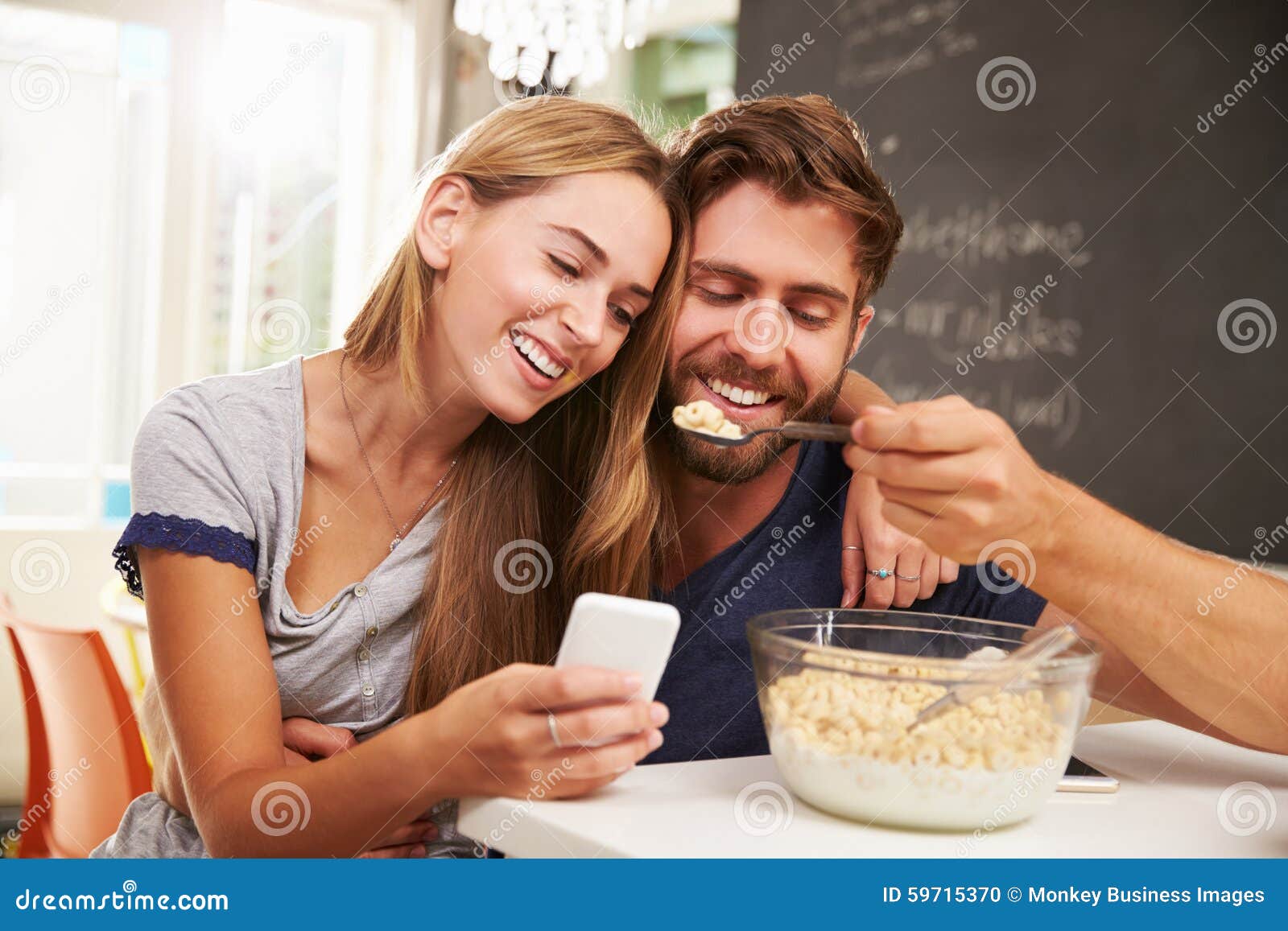 Young Couple Eating Breakfast Whilst Using Mobile Phones Stock Photo ...