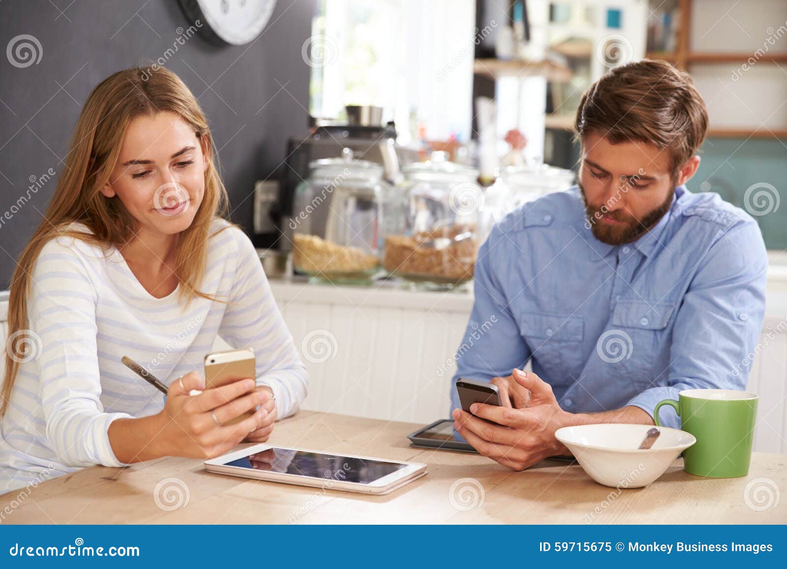 Young Couple Eating Breakfast Whilst Using Mobile Phones Stock Image ...