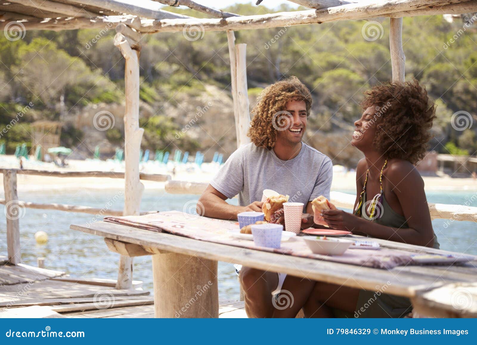 Young Couple Eating at a Table by the Sea Look at Each Other Stock ...