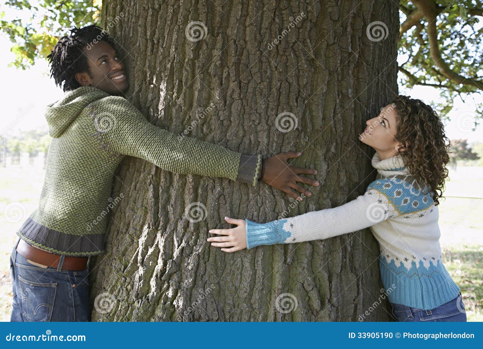 Young Couple Embracing Tree Trunk at Park Stock Photo - Image of ...