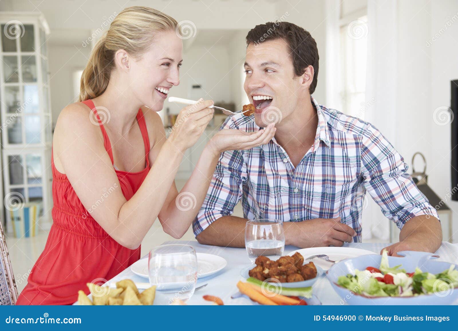 Young Couple Enjoying Meal at Home Stock Photo - Image of couple ...