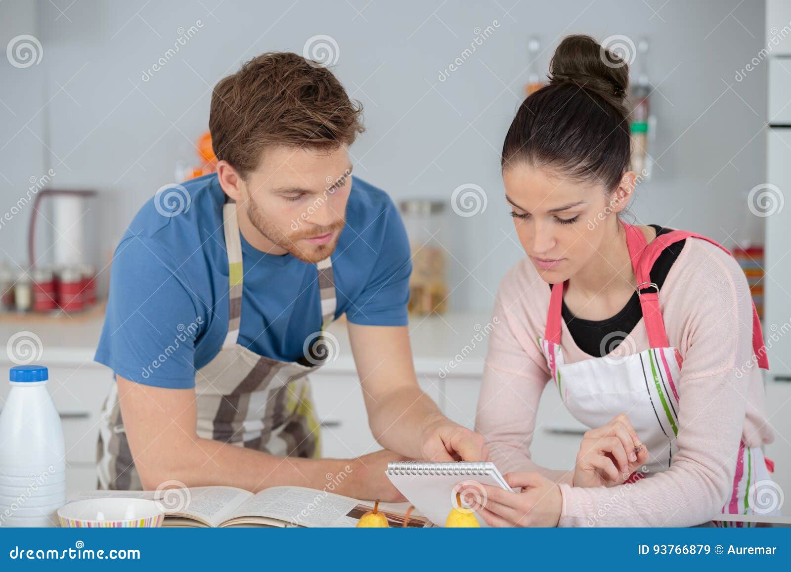 Young Couple Following Recipe in Kitchen Stock Image - Image of recipe ...