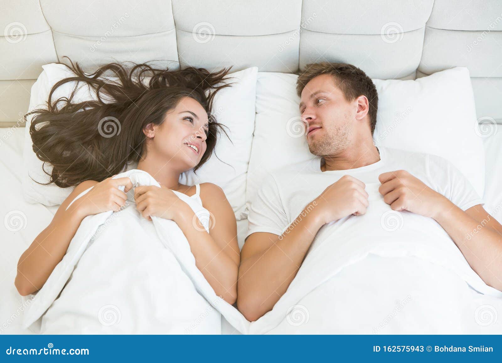 Young Couple Handsome Husband And Beautiful Wife Lying In Bed In Bright