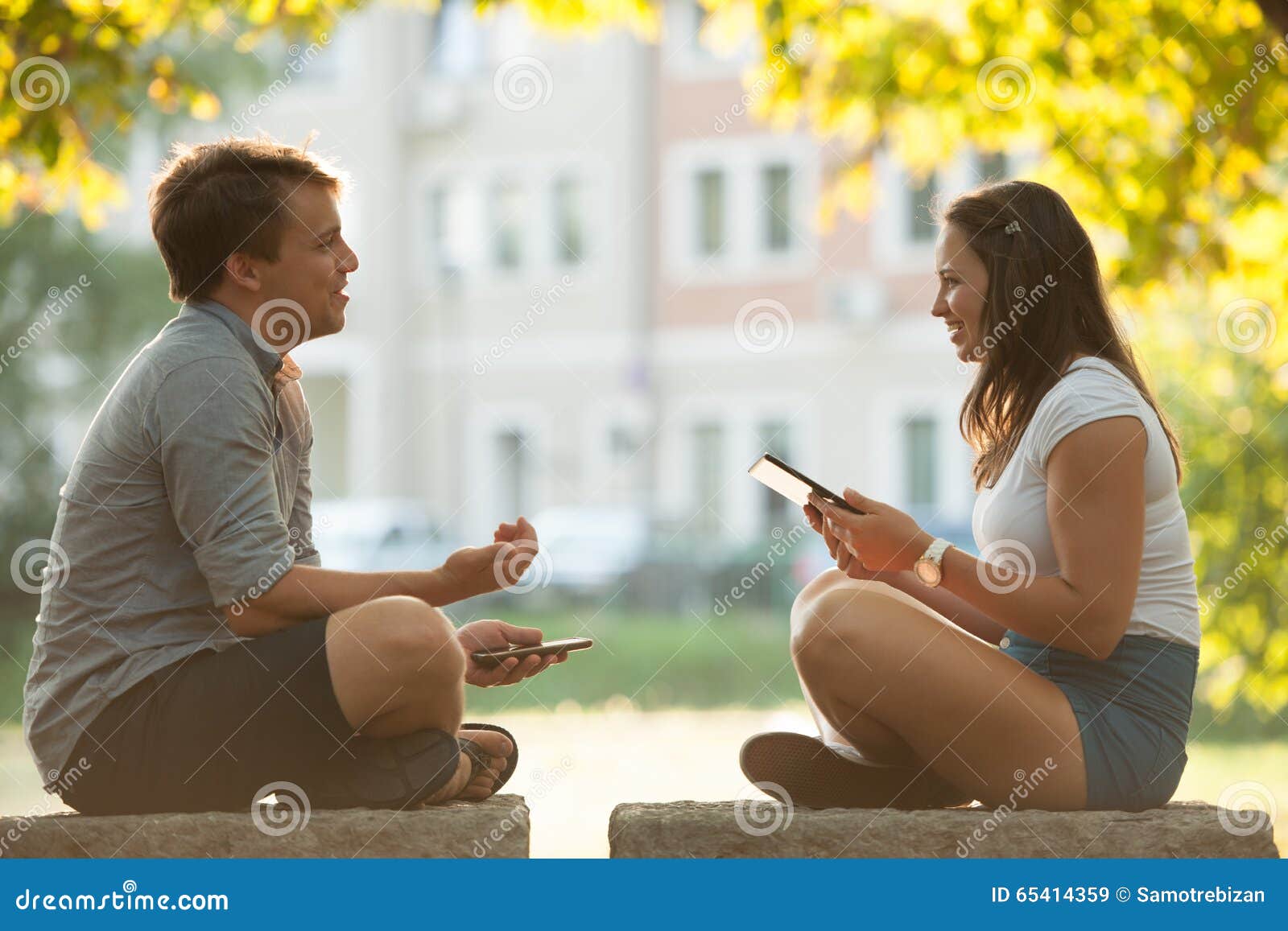 Young Couple Having Fun on a Bench in Park while Socializing Over Web ...