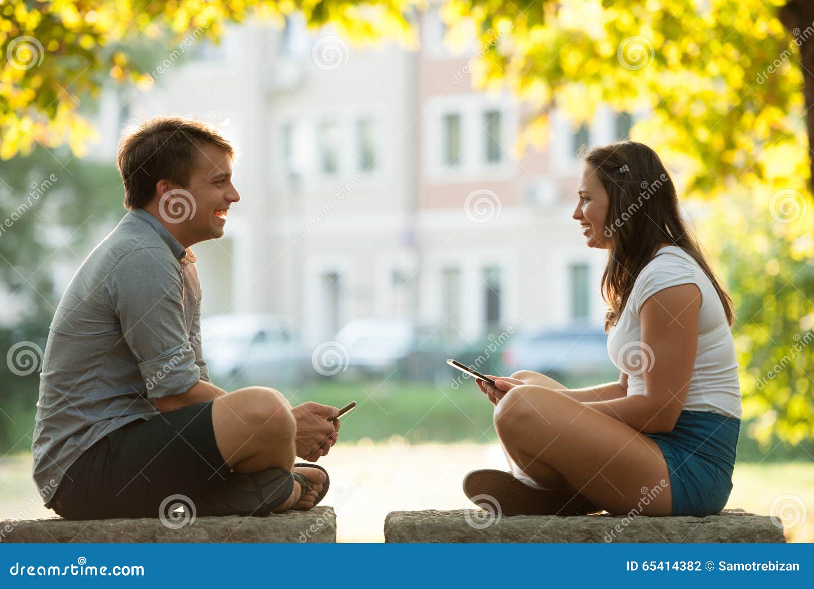 Young Couple Having Fun on a Bench in Park while Socializing Over Web ...